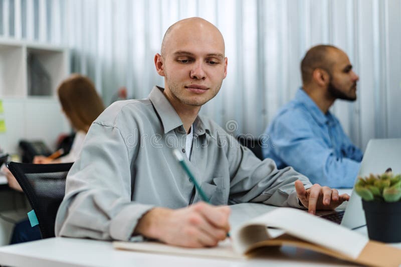 Young Bald Business Man Sitting at Desk in Office, Working on Computer ...