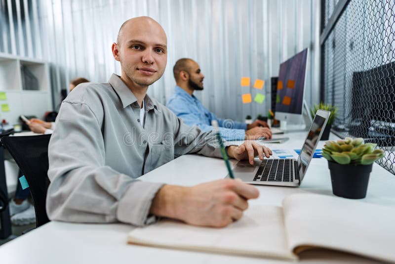Young Bald Business Man Sitting at Desk in Office, Working on Computer ...