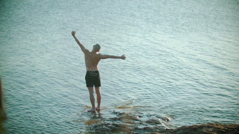 Young Bald Caucasian Man Standing in River and Stretches Himself Up ... Young Bald Caucasian Man Standing in River and Stretches Himself Up ...