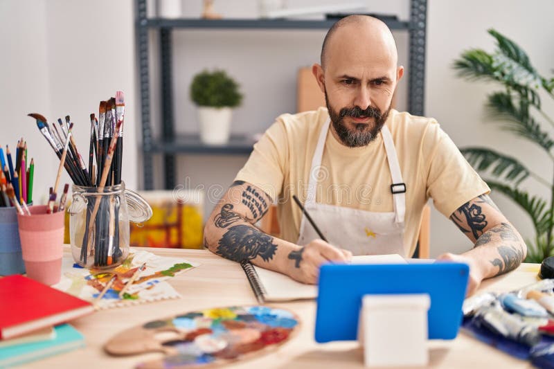 Young Bald Man Artist Drawing on Notebook Looking Touchpad at Art ...