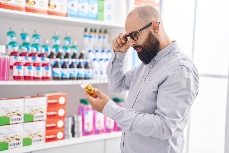 Young Bald Man Customer Reading Pills Label at Pharmacy Stock Photo ...