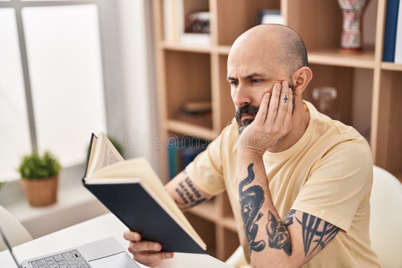 Young Bald Man Reading Book Sitting on Table at Home Stock Image ...