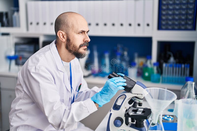 Young Bald Man Scientist Using Microscope at Laboratory Stock Image ...