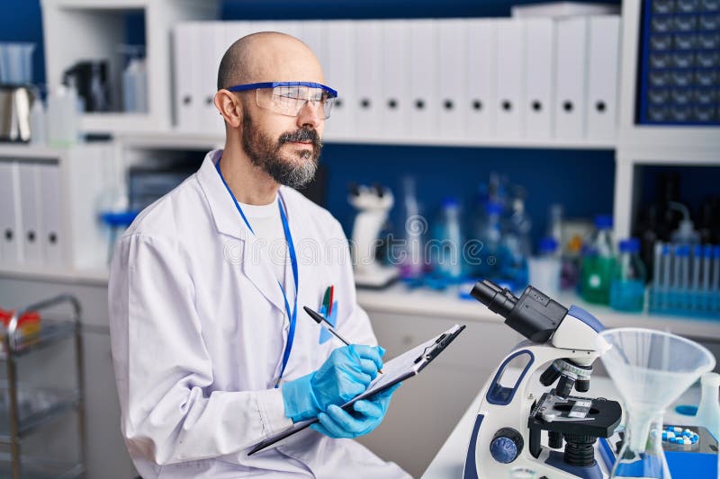 Young Bald Man Scientist Writing Report Working at Laboratory Stock ...