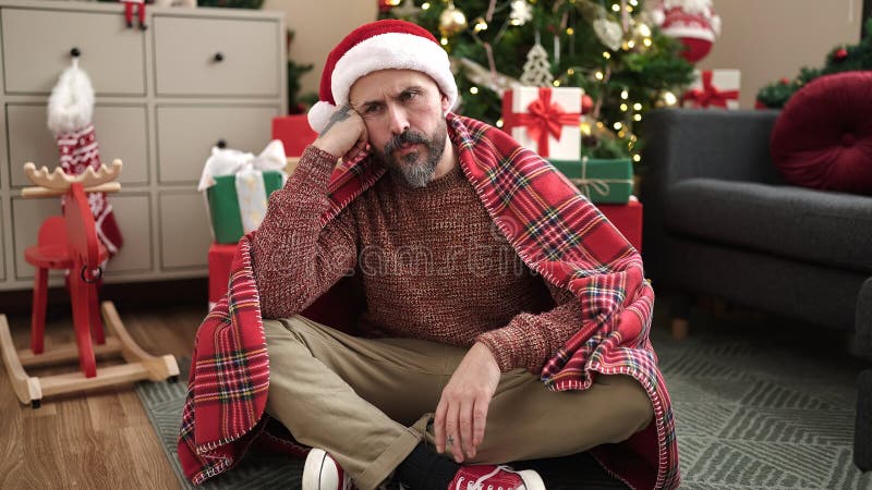 Young Bald Man Sitting by Christmas Tree Looking Upset at Home Stock ...