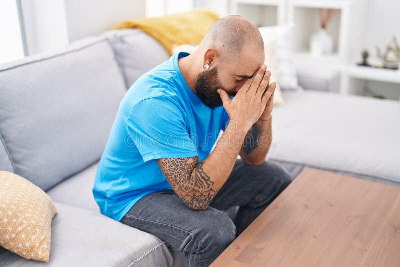 Young Bald Man Stressed Sitting on Sofa at Home Stock Photo - Image of ...
