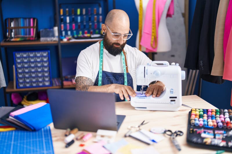 Young Bald Man Tailor Using Sewing Machine and Laptop at Clothing ...
