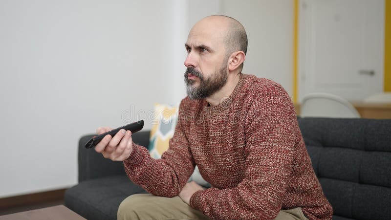 Young Bald Man Watching Tv Sitting on Sofa with Boring Expression at ...