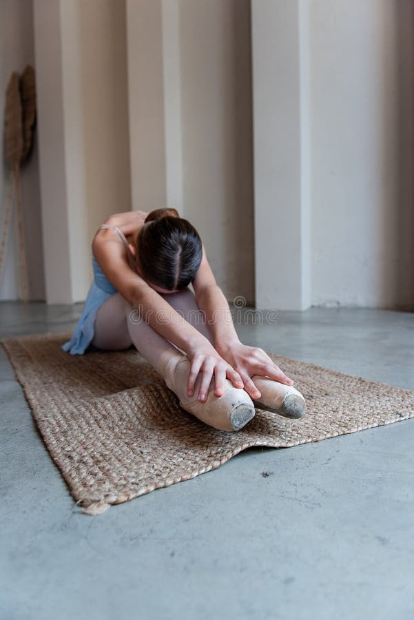 Young Ballerina in Ballet Pointe in Serene Stretch, Bowing Forward ...