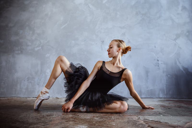 Young Ballerina in a Black Dancing Suit is Posing in a Loft Studio ...