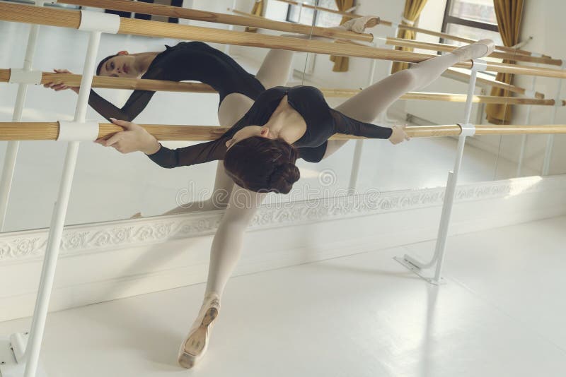 Young Ballerina in a Dance Class at a Ballet Machine Does Stretching ...