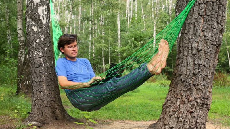 Young Barefoot Man Lies in Hammock and Working Stock Footage - Video of ...