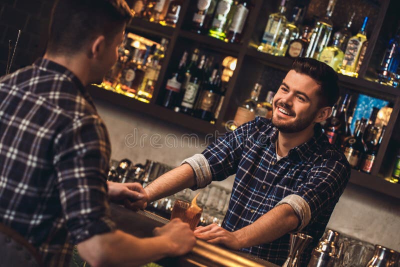 Young Bartender Standing at Bar Counter Talking on Smartphone Cleaning ...