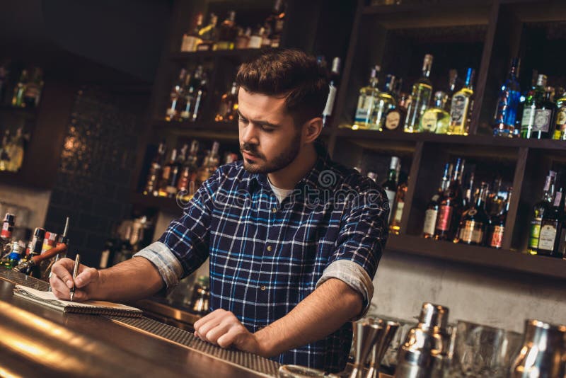 Young Bartender Standing at Bar Counter Writing Receipt Concentrated ...