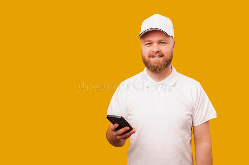 Young Bearded Delivery Man Wearing White Using Phone Over Yellow ...