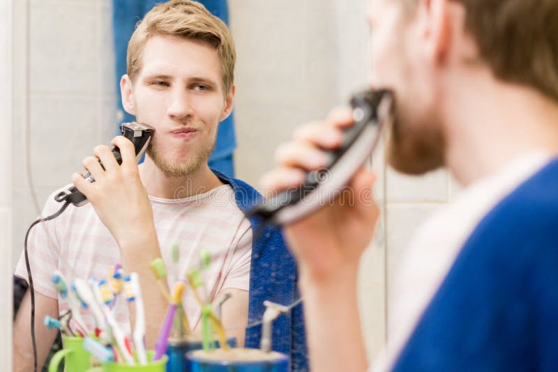 Young Bearded Handsome Man Having Beard with Machine in Bathroom ...