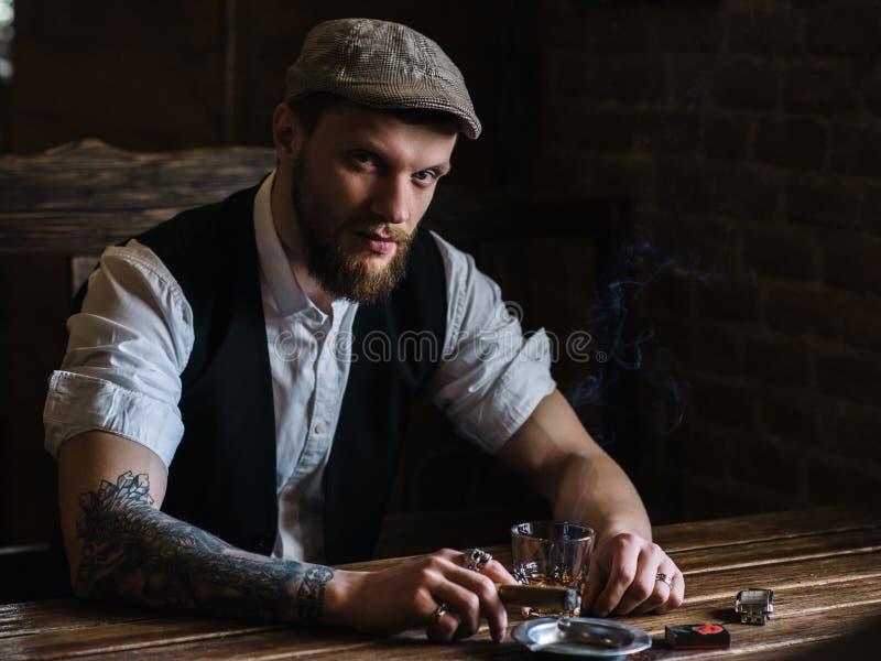 A Young Bearded Man Smoking a Cigar in a Pub Stock Photo - Image of ...