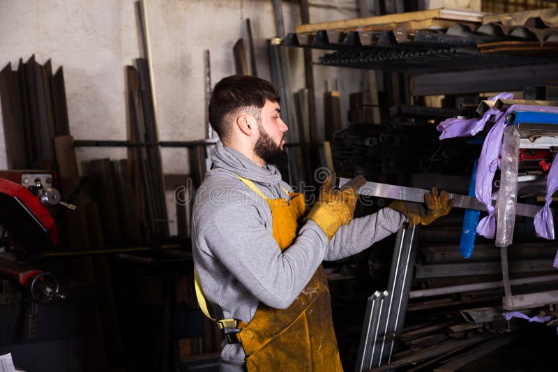 Man Taking Tubes from Rack in Workshop Stock Image - Image of ...