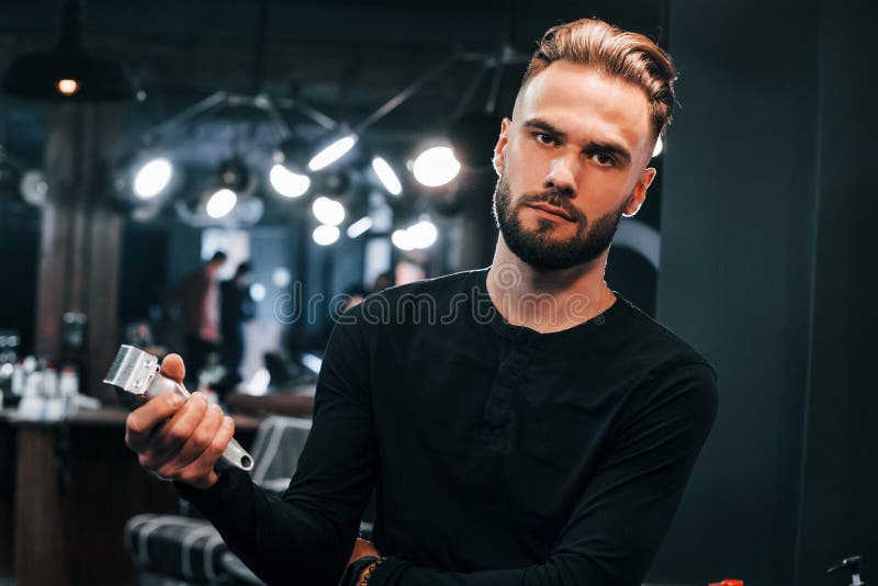 Young Bearded Man Standing in Barber Shop and Holding Clipper Stock ...
