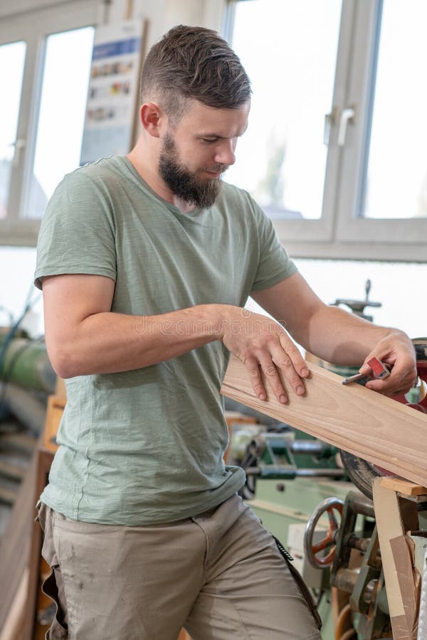 Young Bearded Worker in a Carpenter`s Workshop Using Grinding Machine ...