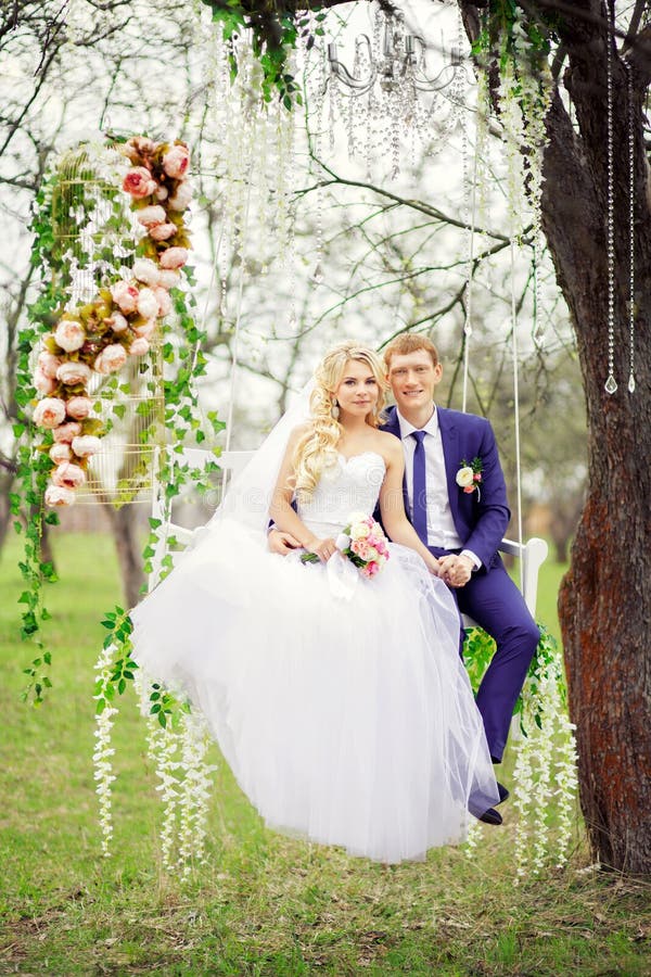Young and Beautiful Bride and Groom Sitting on a White Swing in Stock ...