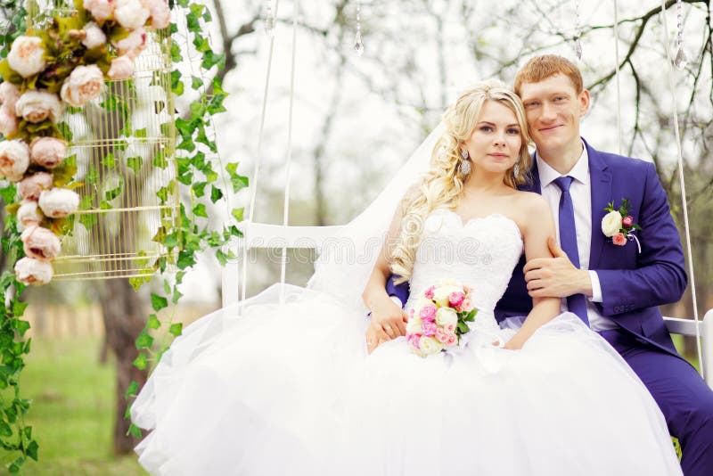 Young and Beautiful Bride and Groom Sitting on a White Swing in Stock ...