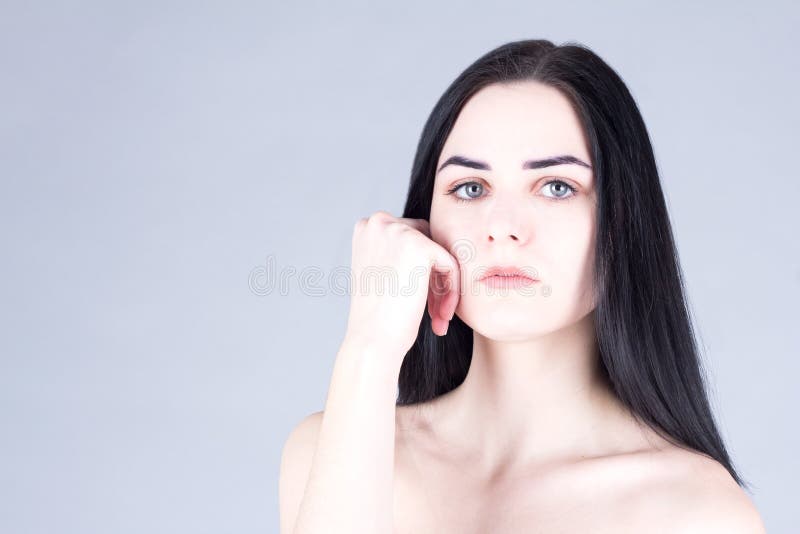 Young, Beautiful Brunette Touching Her Cheek by Hand and Looking at the ...