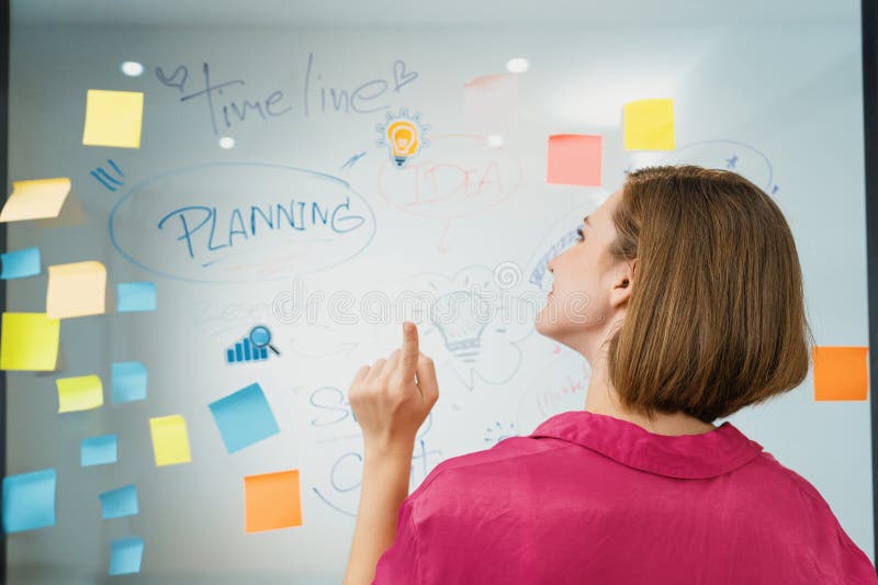 Businesswoman Puts Sticker on Glass Board while Finding a Solution ...