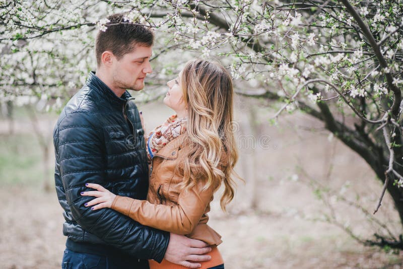 Young Beautiful Couple in a Blooming Garden Stock Image - Image of ...