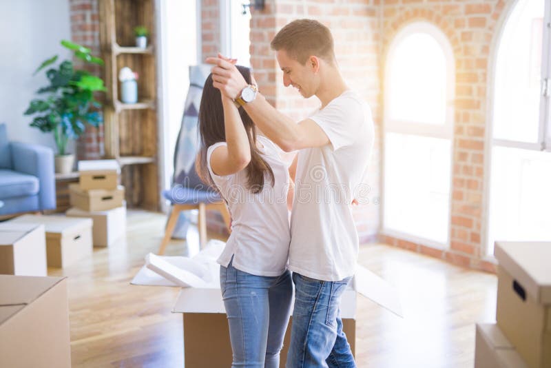 Young Beautiful Couple Dancing at New Home Around Cardboard Boxes Stock ...