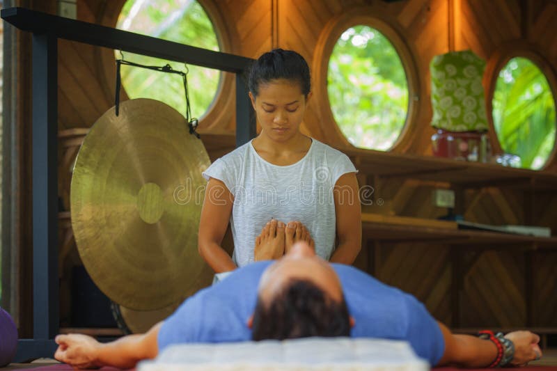 Young Beautiful And Exotic Asian Balinese Wellness Therapist Giving Body Thai Massage To