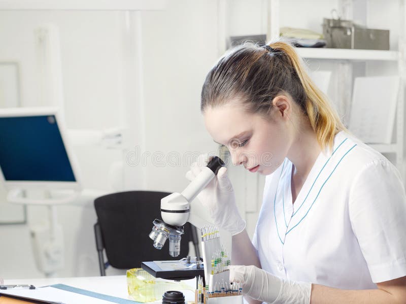 Young Beautiful Girl Lab Assistant Looks in a Microscope in a La Stock ...