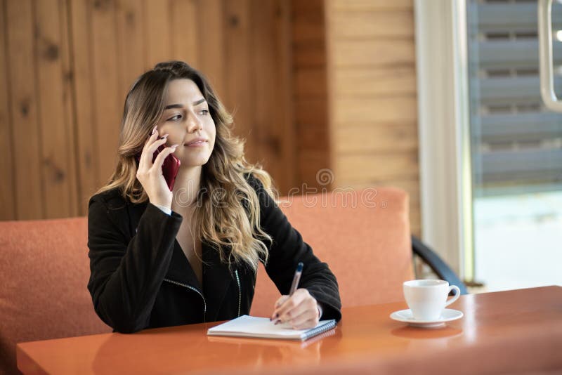 Young Beautiful Girl Makes a Phone Call in a Cafe, Writes Notes in a ...