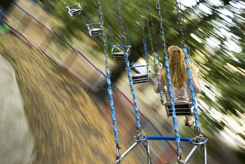 Young Beautiful Girl Rides on a Swing Suspended on Chains. Stock Photo ...