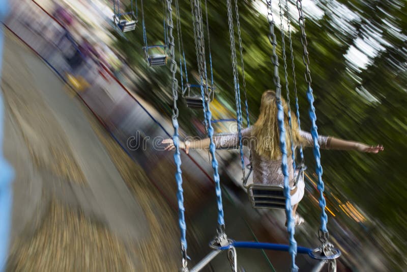 Young Beautiful Girl Rides on a Swing Suspended on Chains. Stock Image ...