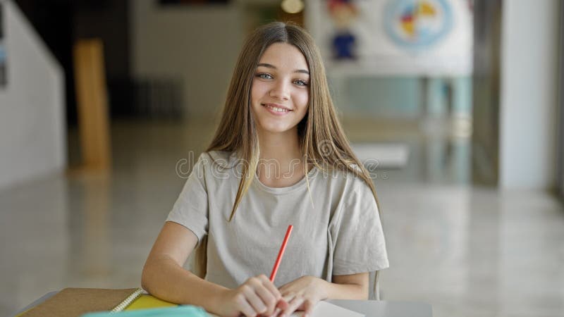Young Beautiful Girl Student Writing on Paper Smiling at Library Stock ...