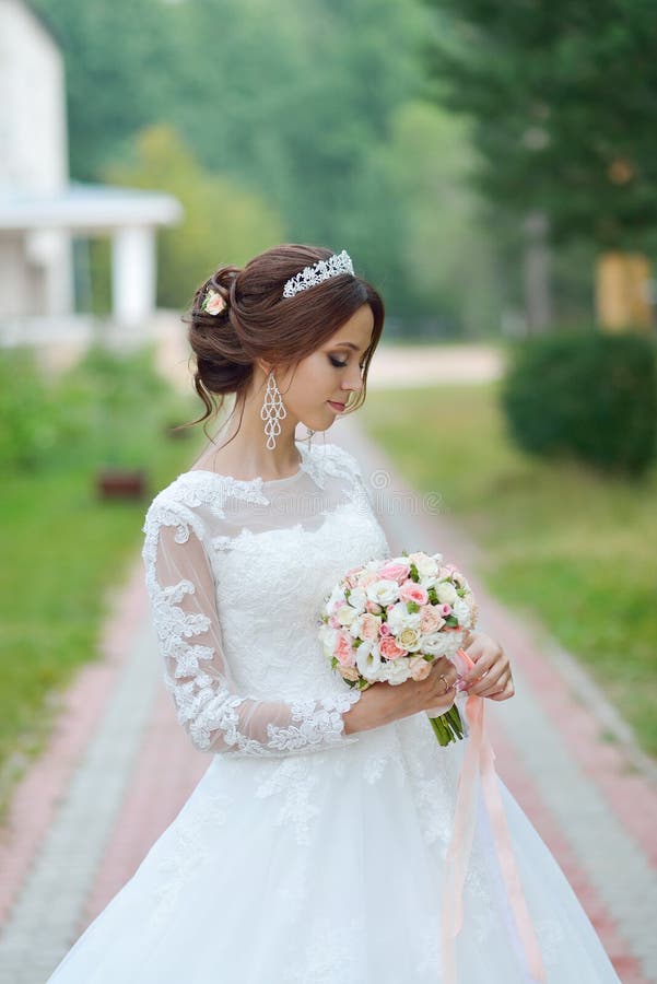 Young Beautiful Happy Bride with Flower Bouquet in Park Stock Photo ...