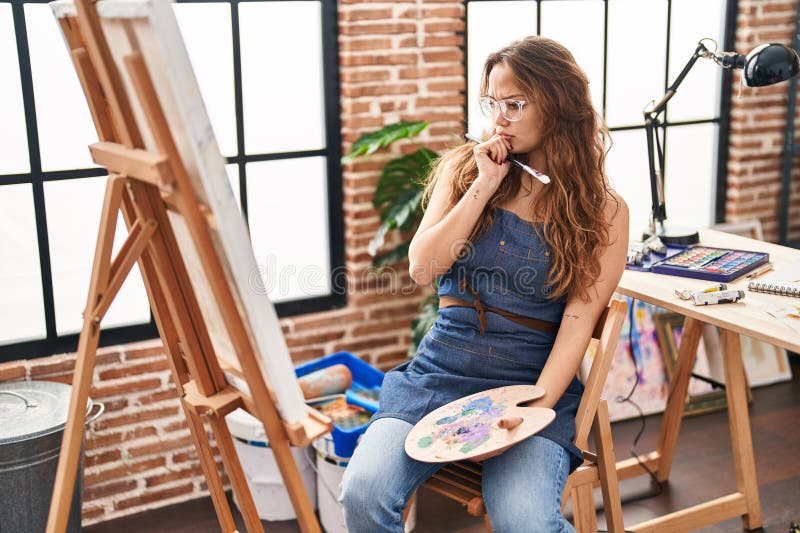 Young Beautiful Hispanic Woman Artist Looking Draw with Doubt Expression at Art Studio Stock ...