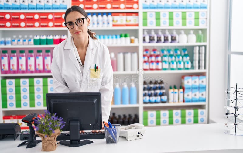 Young Beautiful Hispanic Woman Pharmacist Using Computer at Pharmacy ...