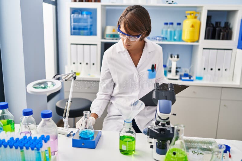 Young Beautiful Hispanic Woman Scientist Weighing Sample at Laboratory ...