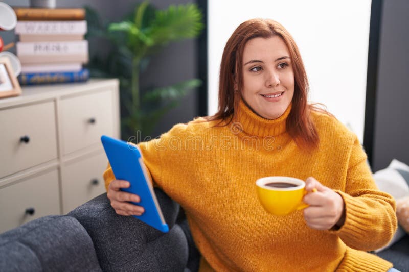 Young Beautiful Plus Size Woman Using Touchpad Drinking Coffee Sitting ...