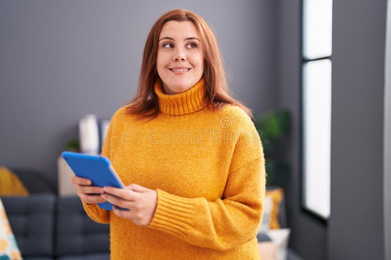 Young Beautiful Plus Size Woman Using Touchpad Standing at Home Stock ...