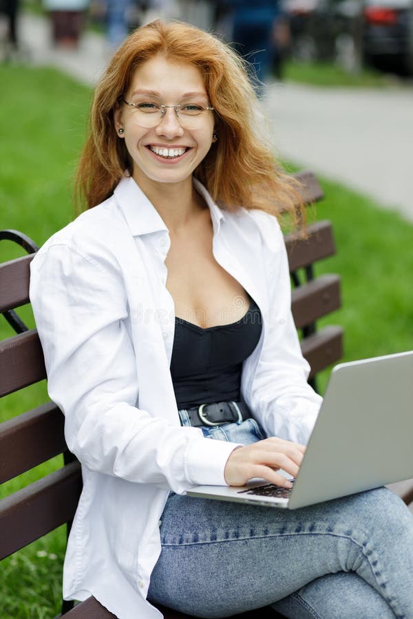 Young Beautiful Redhead Girl Student Using Her Computer Sitting on the ...