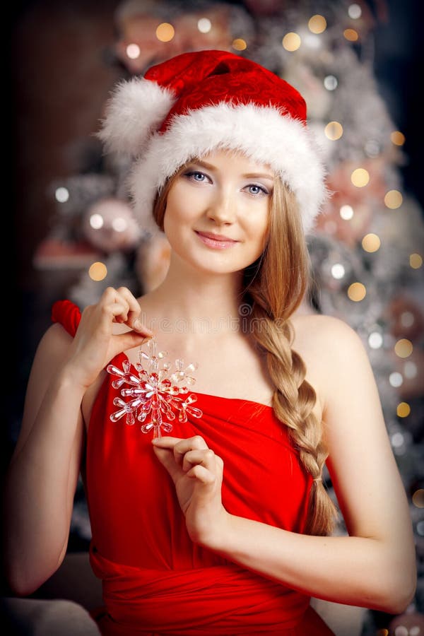 Young Beautiful Smiling Santa Woman Near The Christmas Tree