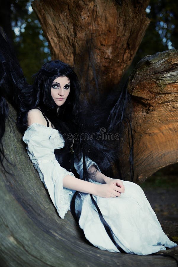 Young Beautiful Witch with Long Dark Hair in Root of Old Tree Stock ...
