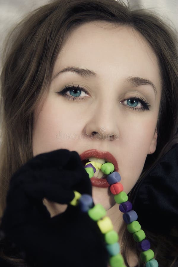 Young Beautiful Woman Biting Multi-coloured Beads Stock Photo - Image ...
