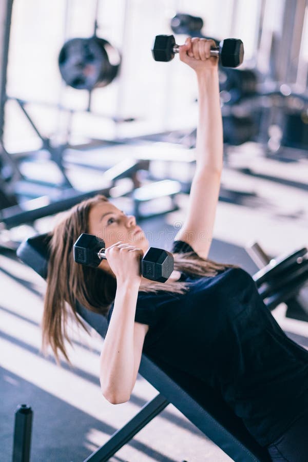 Young Beautiful Woman Doing Exercises with Dumbbell in Gym Stock Photo ...
