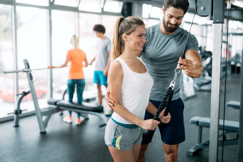 Young Beautiful Woman Doing Exercises with Personal Trainer Stock Image ...