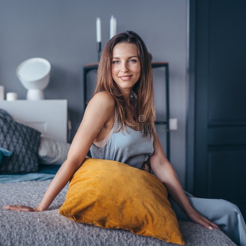 Young Beautiful Woman Sitting on Bed at Home. Stock Photo - Image of ...