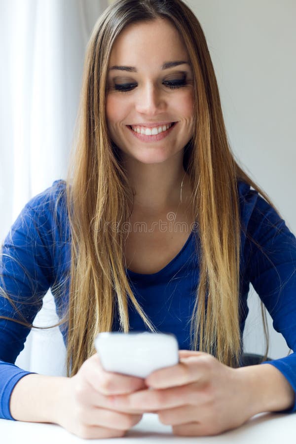 Young Beautiful Woman Using Her Mobile Phone at Home. Stock Photo ...